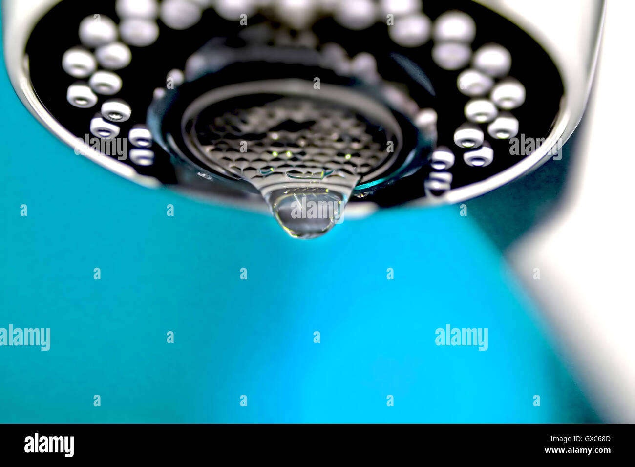 A macro of a white tap / faucet dripping with blue background Stock ...