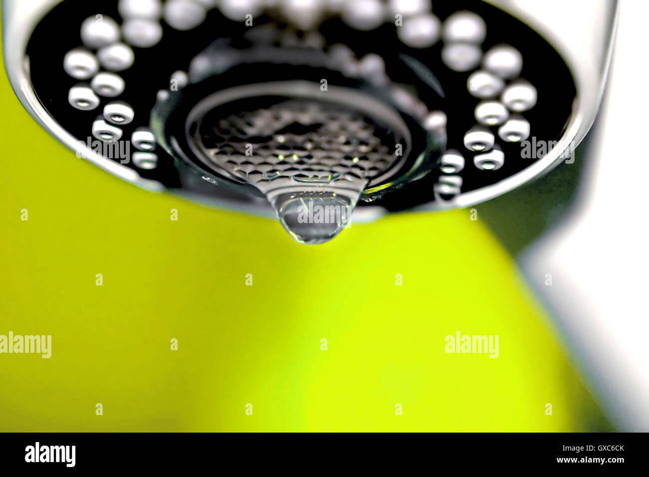 A macro of a white tap / faucet dripping with yellow background Stock ...