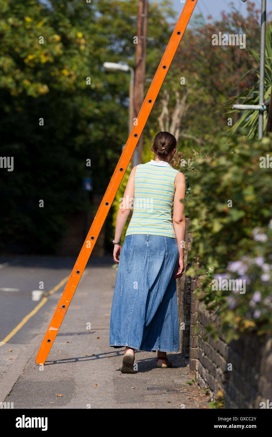 Pedestrian / lady / young woman / people / person walking under a ...