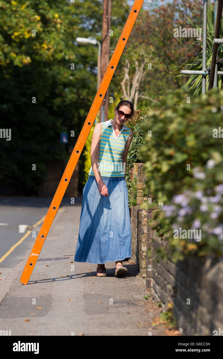 Pedestrian / lady / young woman / people / person walking under a ...