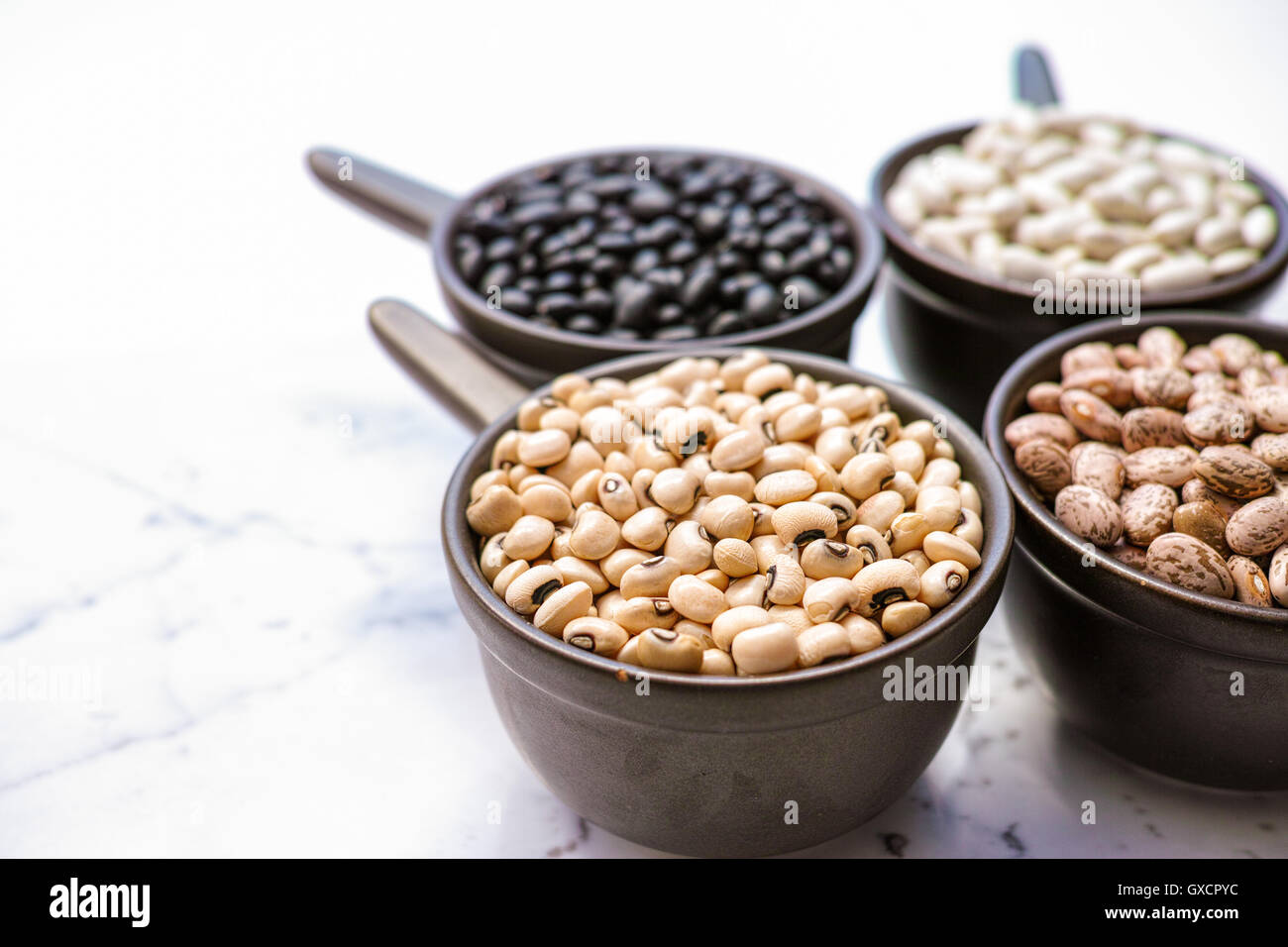 Beans variety/ different types of beans in ceramic bowls on black ...