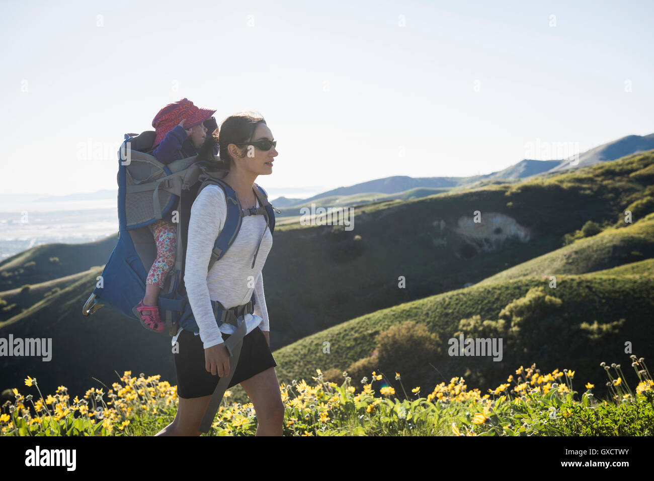 Mother carrying young daughter, hiking the Bonneville Shoreline Trail ...