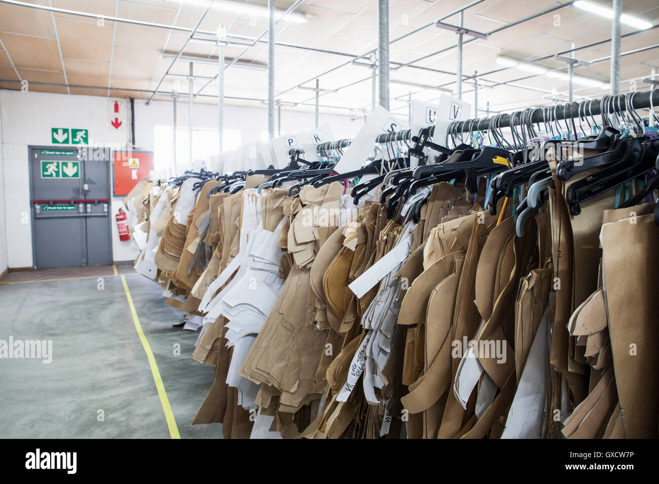 Sewing patterns hanging on clothes rail in sewing factory sample room ...