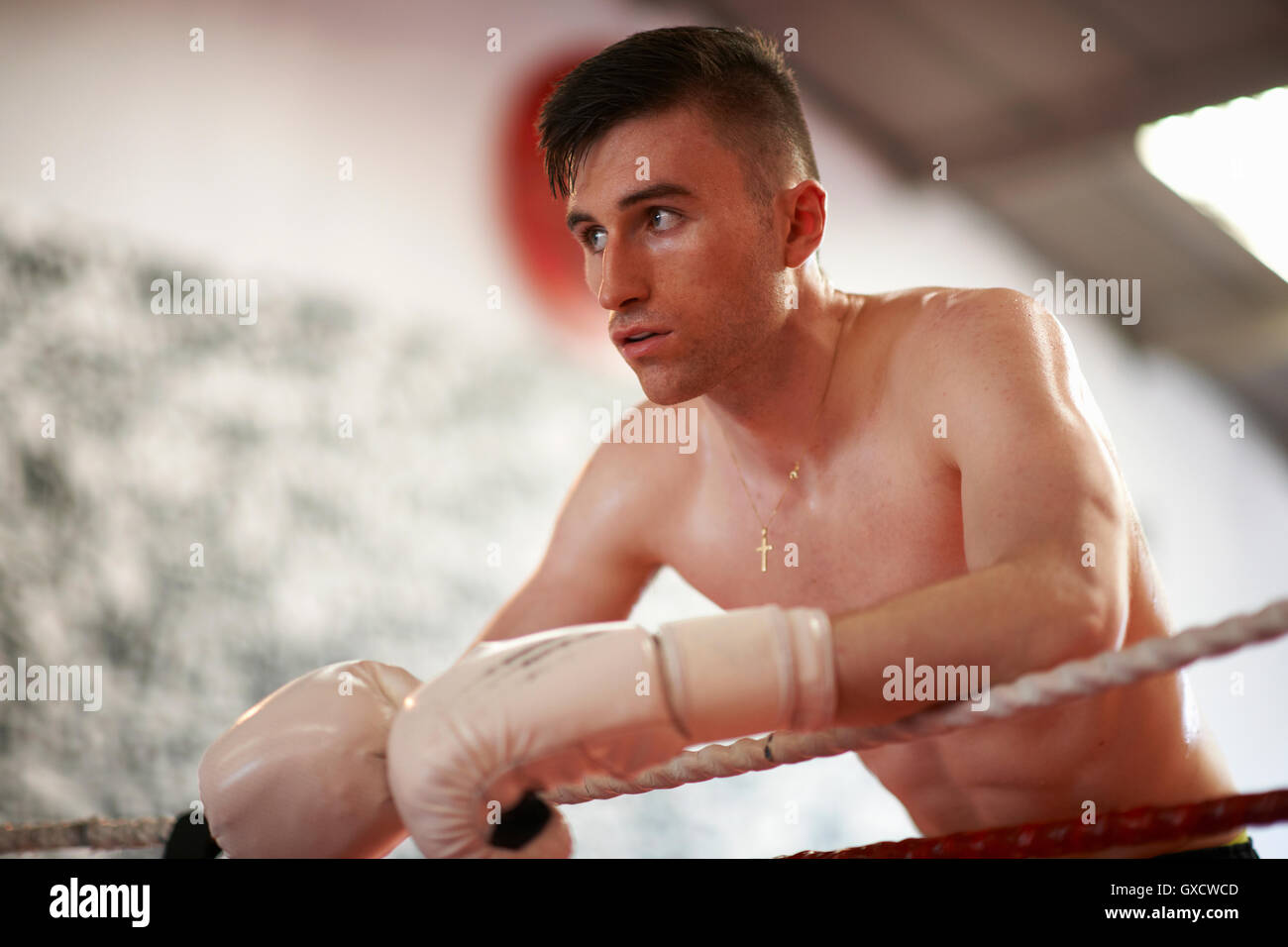 Boxer leaning on ropes of boxing ring Stock Photo - Alamy