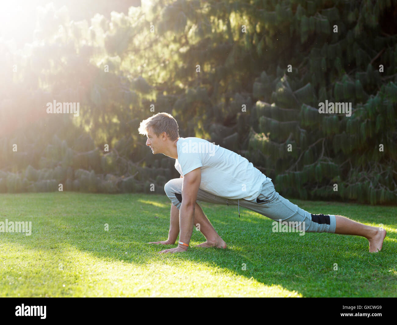 Young man exercising outdoors, stretching Stock Photo - Alamy