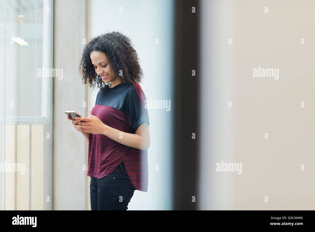 Female designer reading smartphone update in design studio Stock Photo ...
