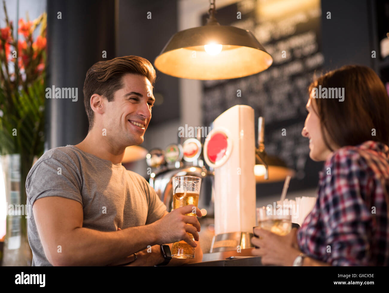 Young couple talking at bar in evening Stock Photo - Alamy