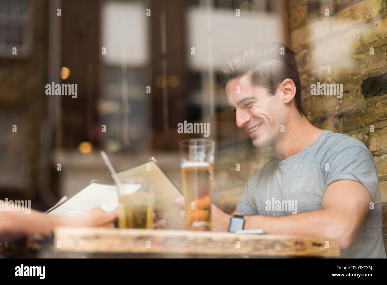 Window view of young man reading menu in restaurant Stock Photo - Alamy
