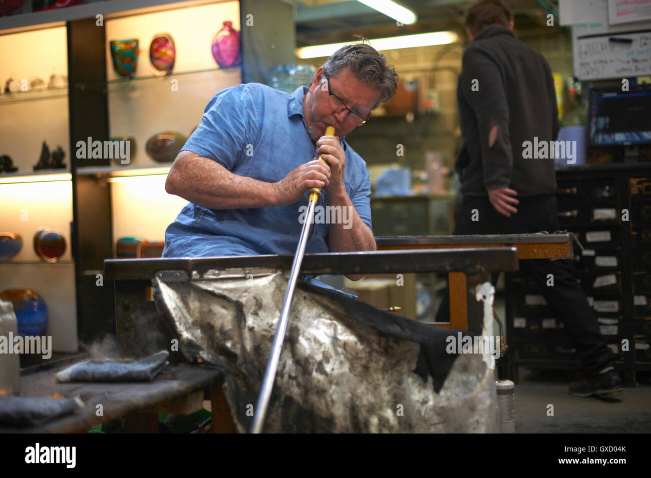 Glassblower in workshop using blowpipe Stock Photo - Alamy