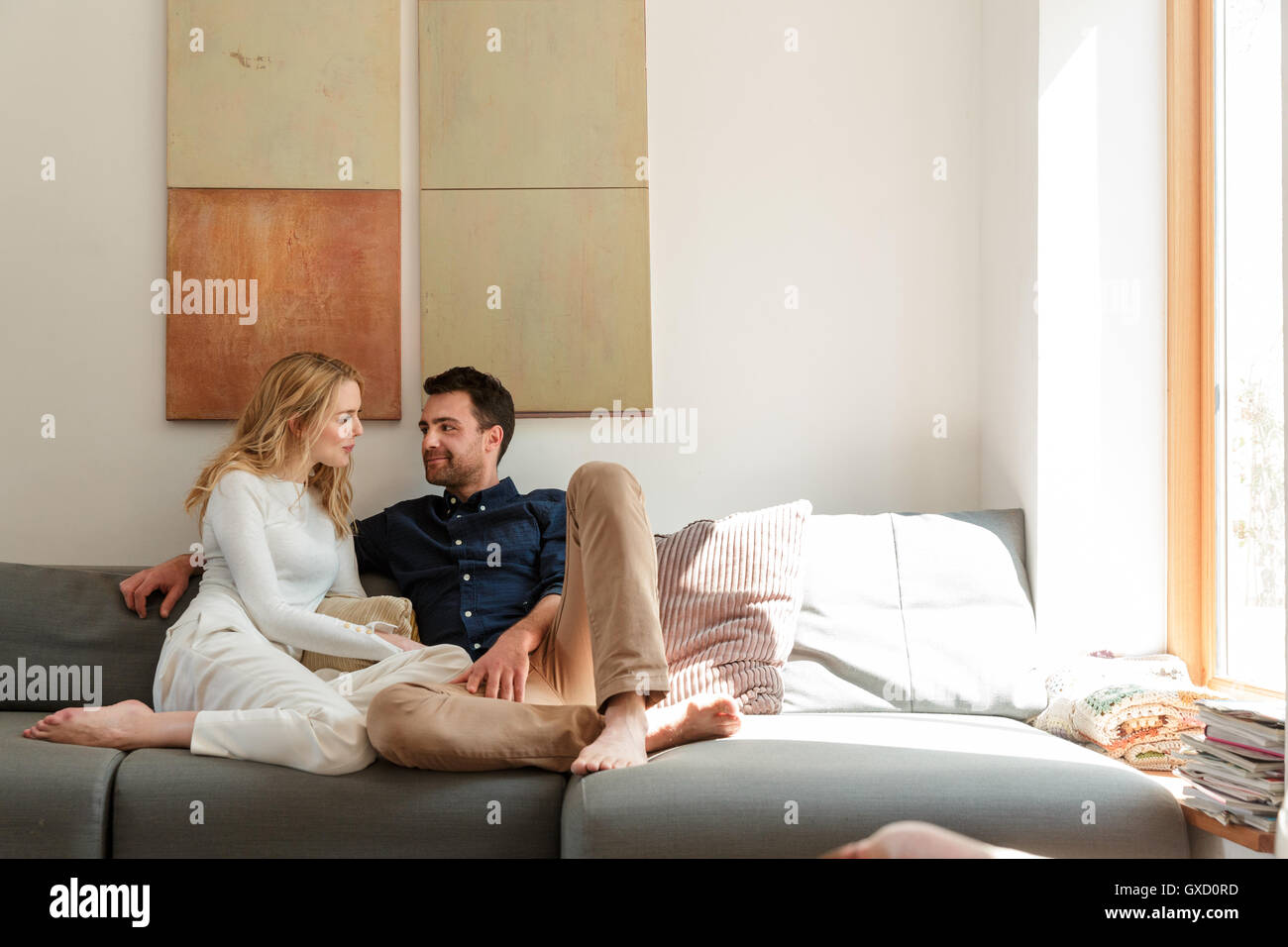 Couple snuggling on sofa Stock Photo - Alamy