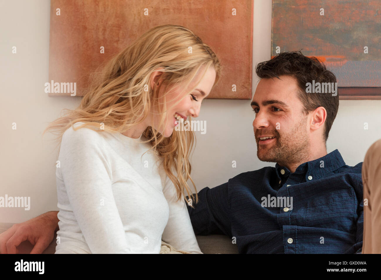Couple snuggling together smiling Stock Photo - Alamy