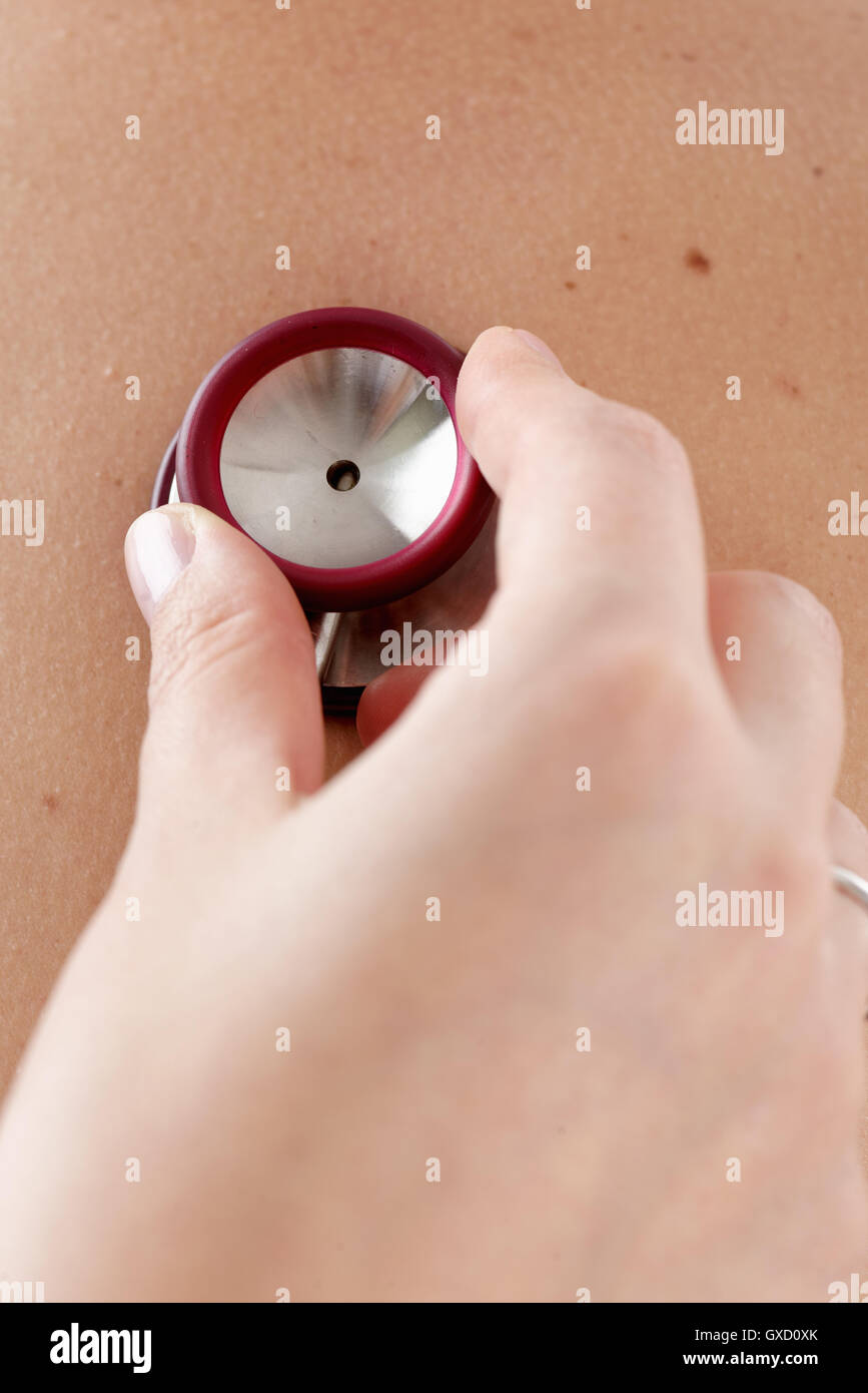 Doctor examining patients with stethoscope Stock Photo - Alamy