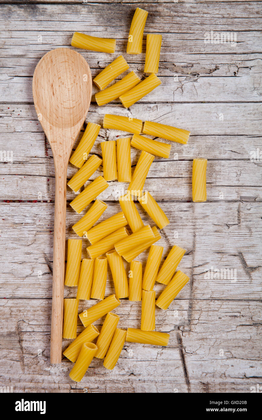 raw macaroni and wooden spoon Stock Photo - Alamy