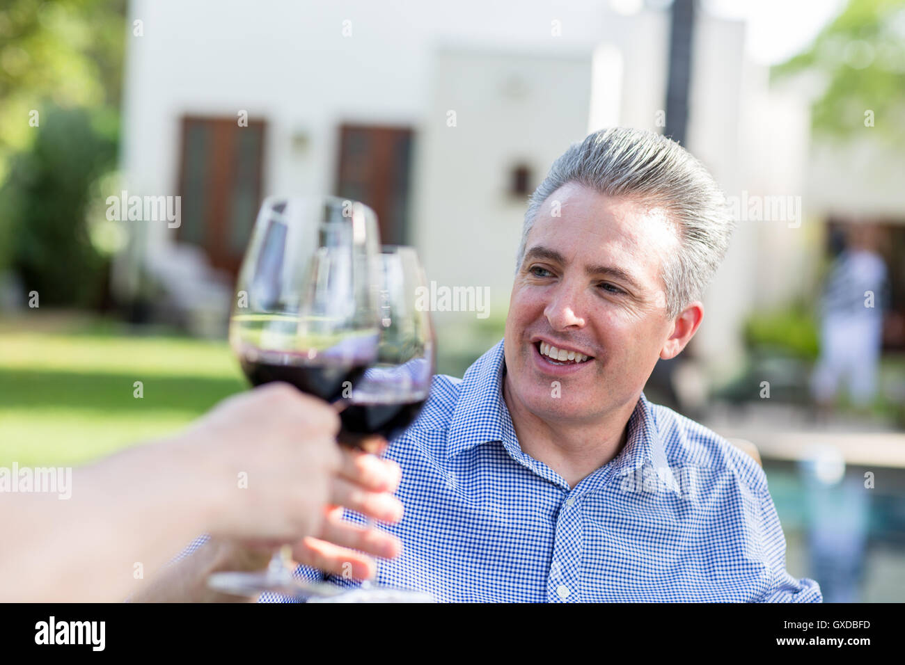 Mature couple making a red wine toast in garden Stock Photo - Alamy