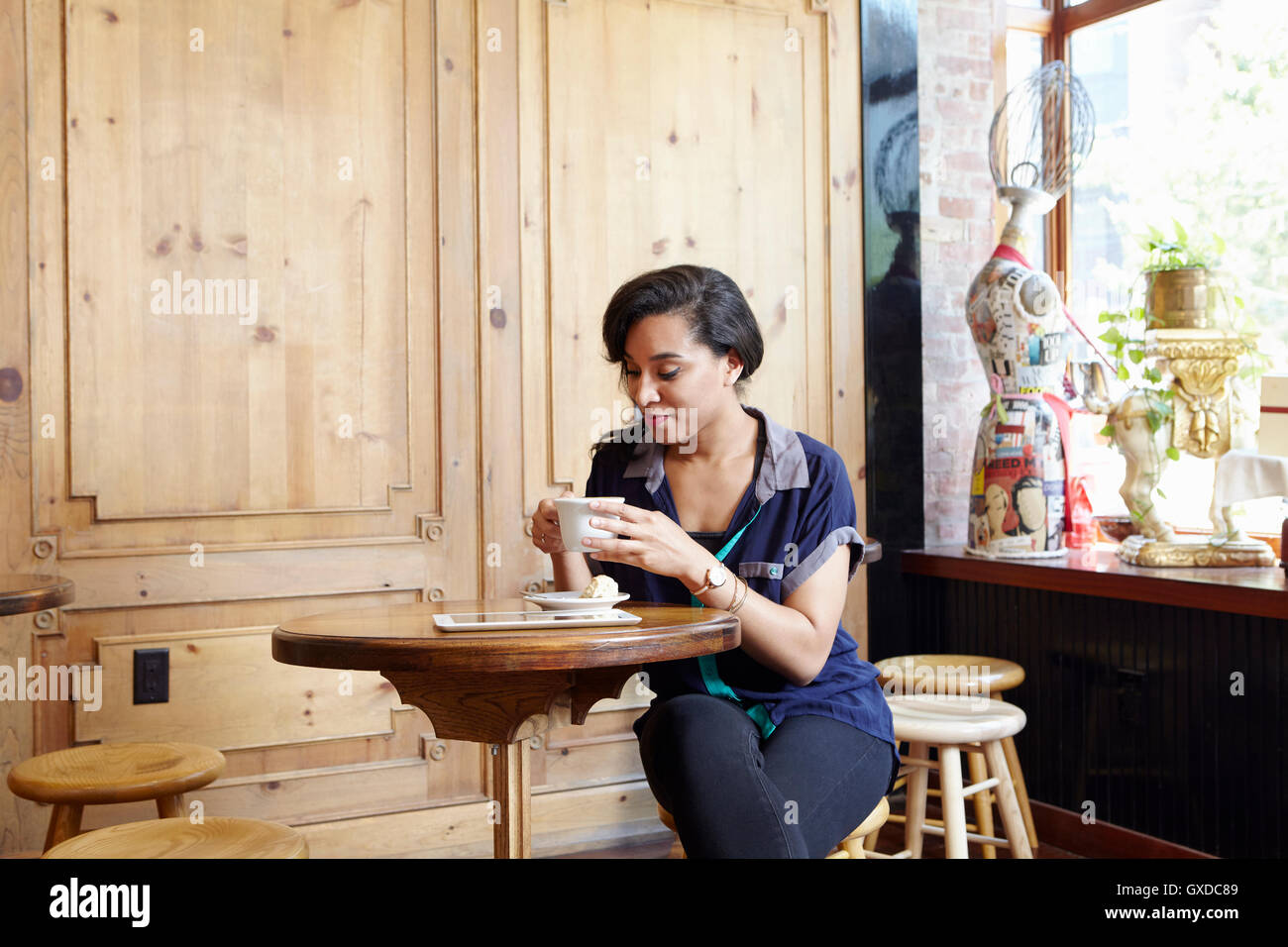 Young woman sitting in cafe, drinking coffee Stock Photo - Alamy