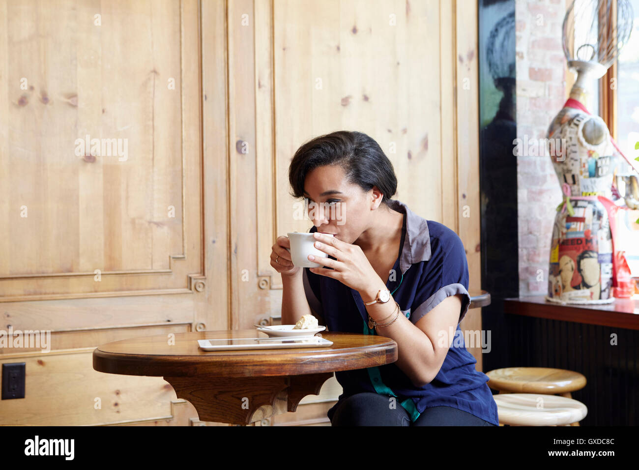 Young woman sitting in cafe, drinking coffee Stock Photo - Alamy