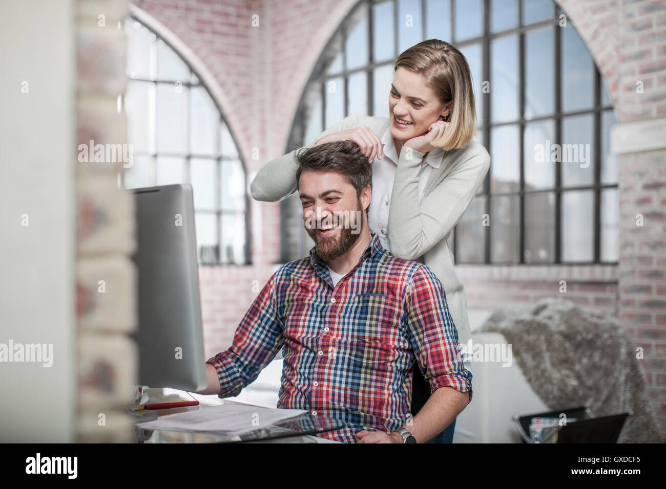 Couple at home, using computer, laughing Stock Photo - Alamy