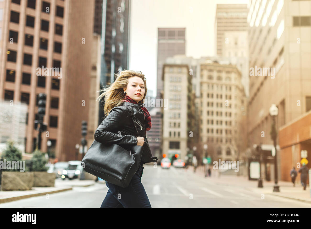 Woman crossing road in urban area, Boston, Massachusetts, USA Stock ...