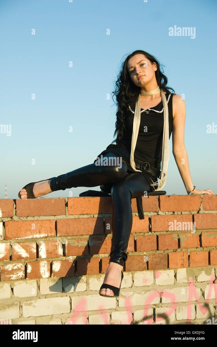 Pretty girl sitting on roof Stock Photo - Alamy