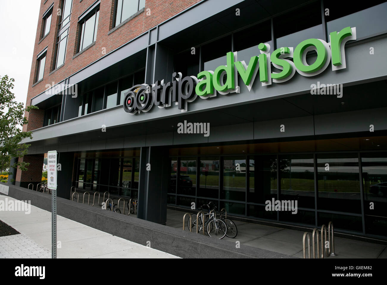 A logo sign outside of the headquarters of TripAdvisor, Inc., in ...