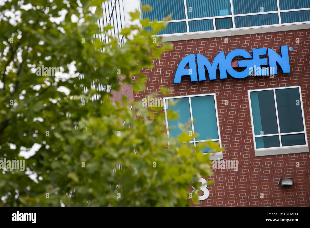 A logo sign outside of a facility occupied by Amgen in Woburn ...