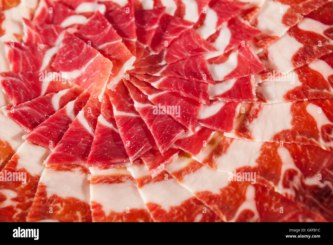 Circular decorative arrangement of iberian cured ham on plate ...