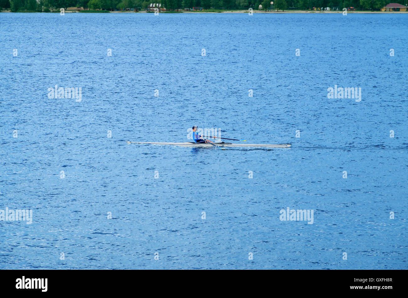 Oarsman on a single boat during a morning workout on the rowing channel ...