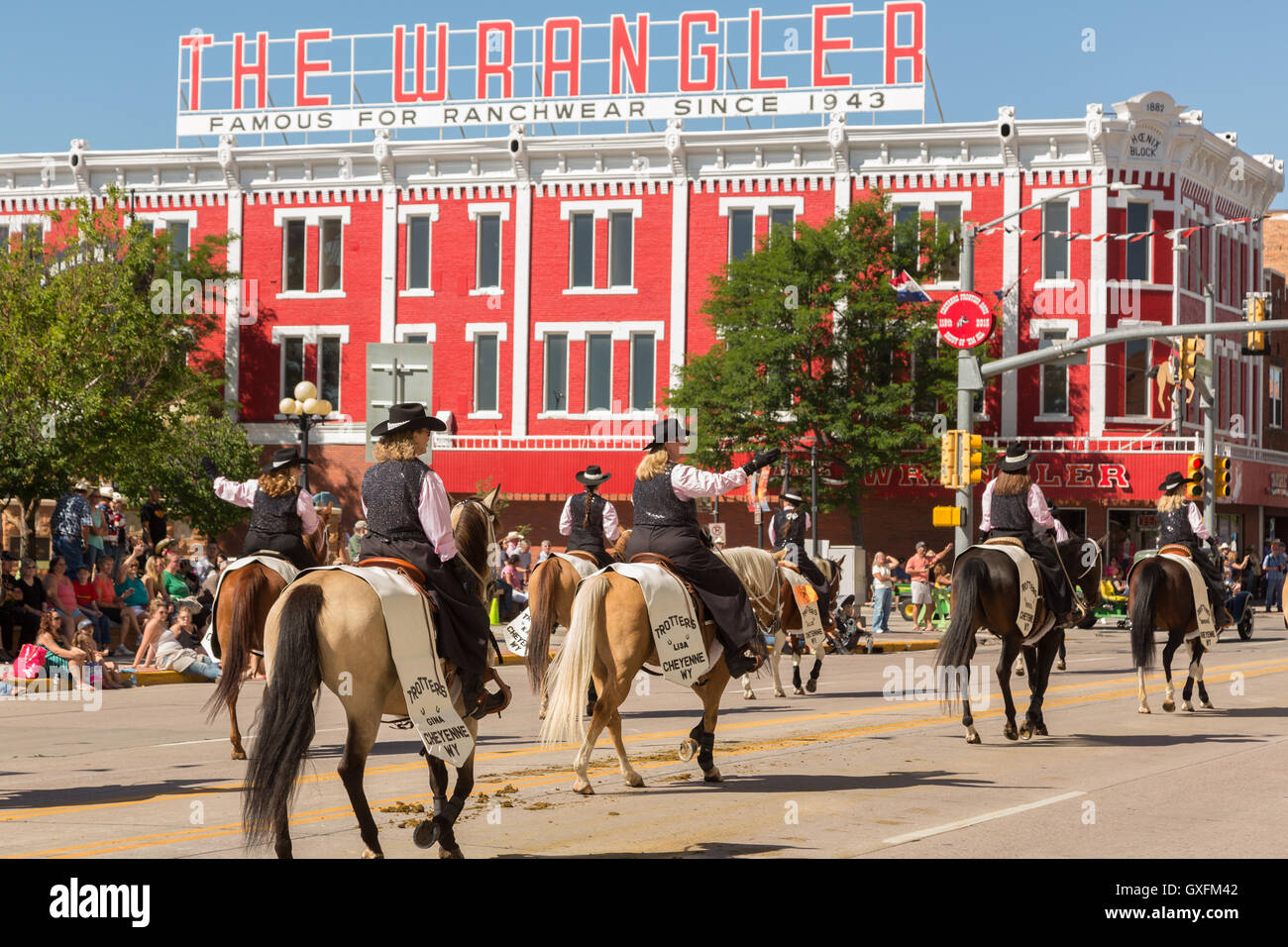 Cowboys on horseback ride past the Wrangler western wear store during ...