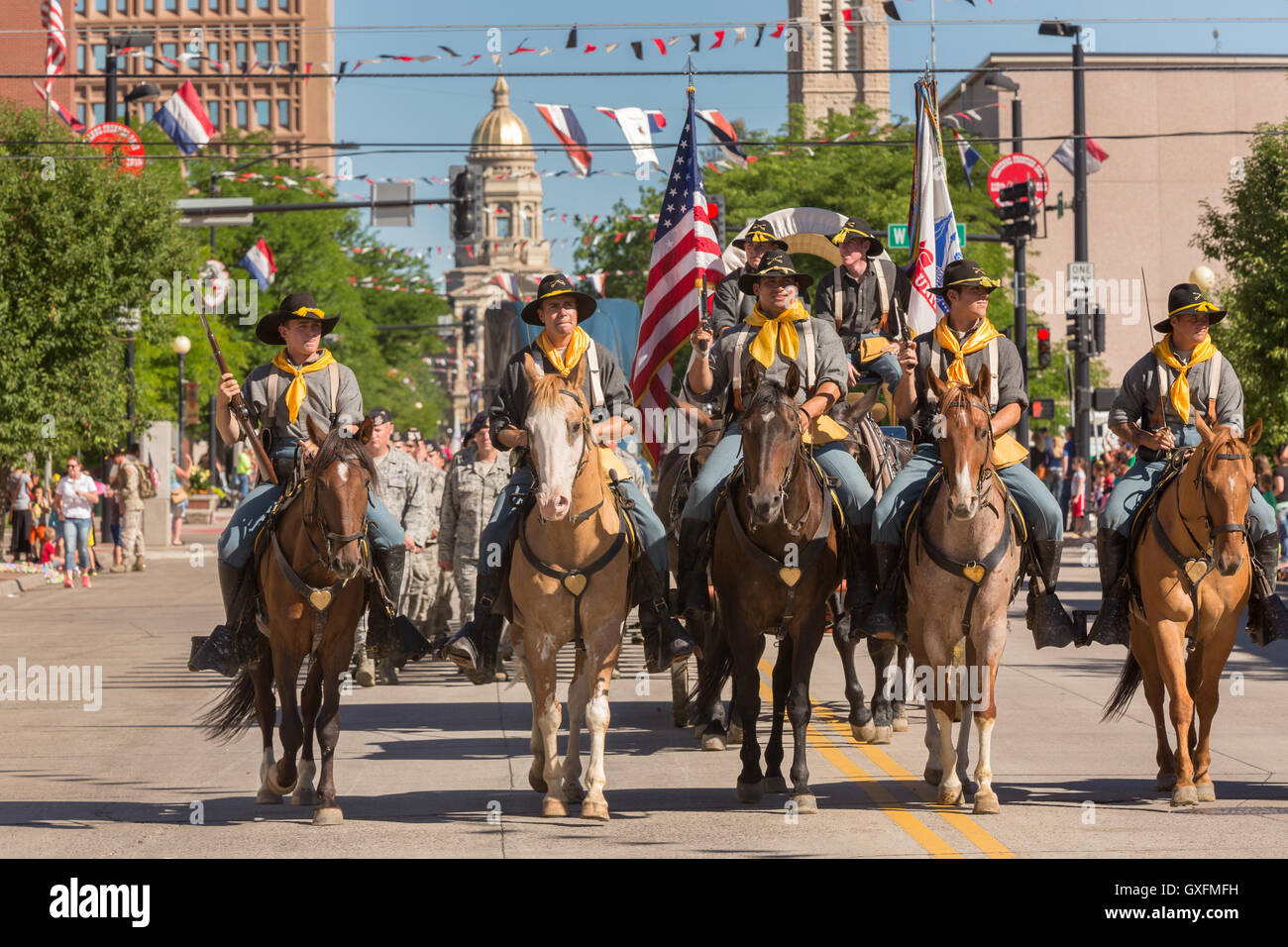 Cowboys and soldiers dressed in period costume riding in the Cheyenne ...
