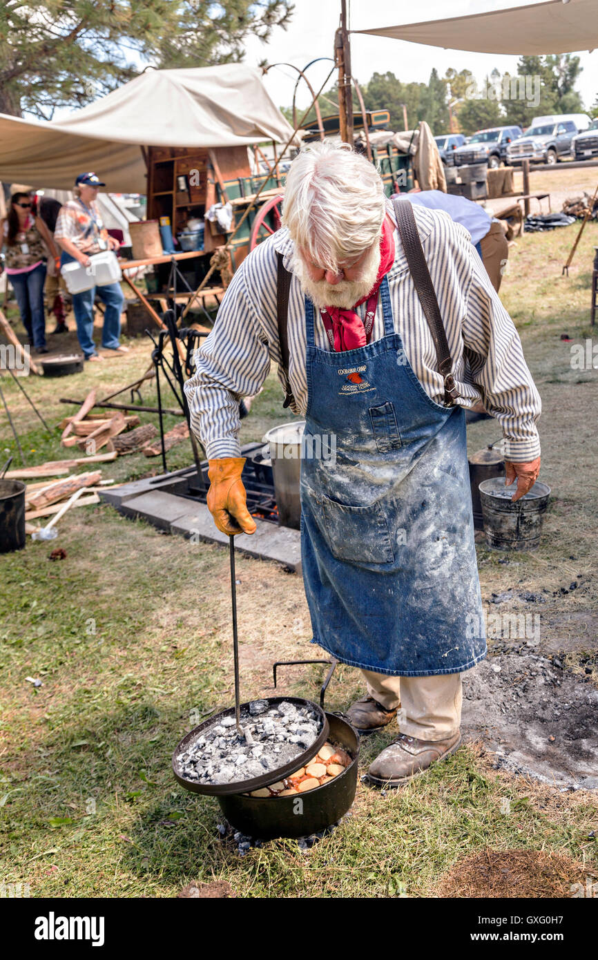 An old cowboy cook prepares biscuits using an iron pot during a chuck ...