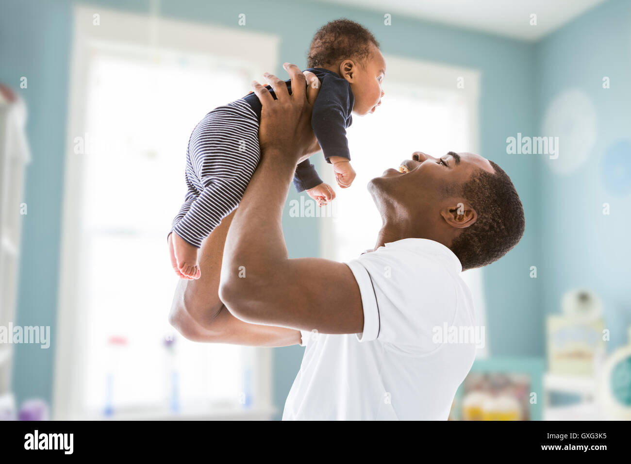 Black father lifting baby son Stock Photo - Alamy