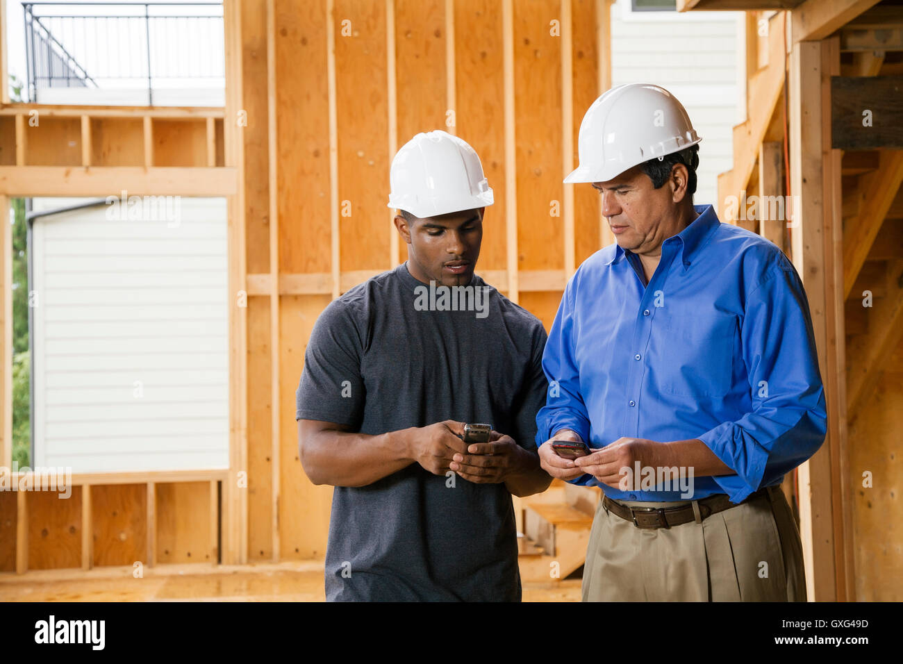 Construction workers texting on cell phones Stock Photo - Alamy