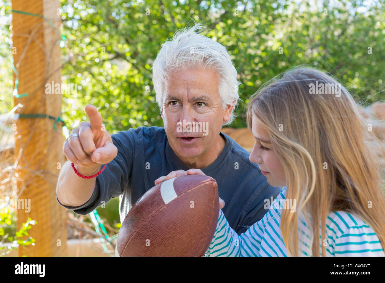 Caucasian grandfather showing granddaughter how to aim football Stock ...