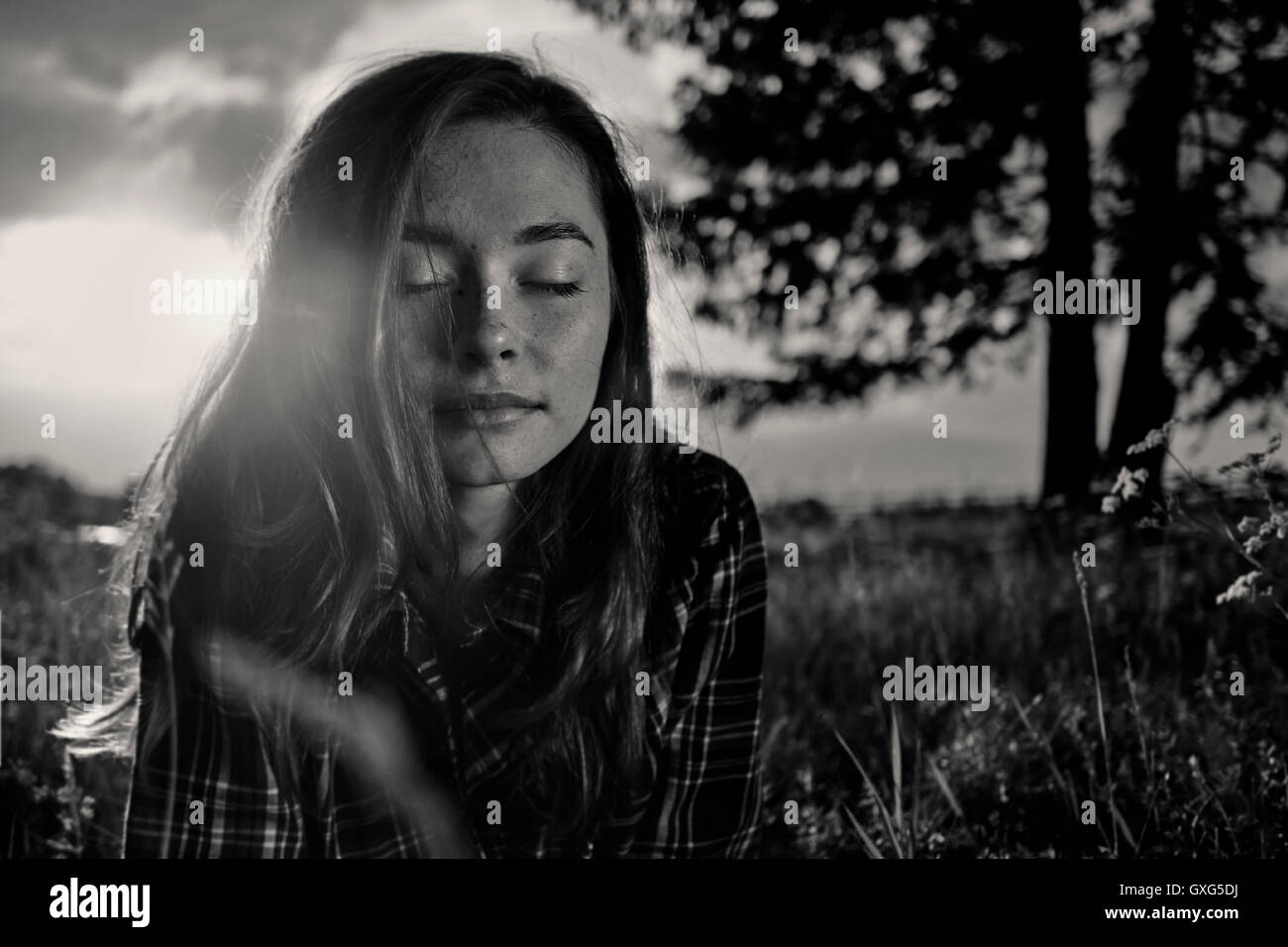 Pensive Caucasian girl laying in grass field Stock Photo - Alamy