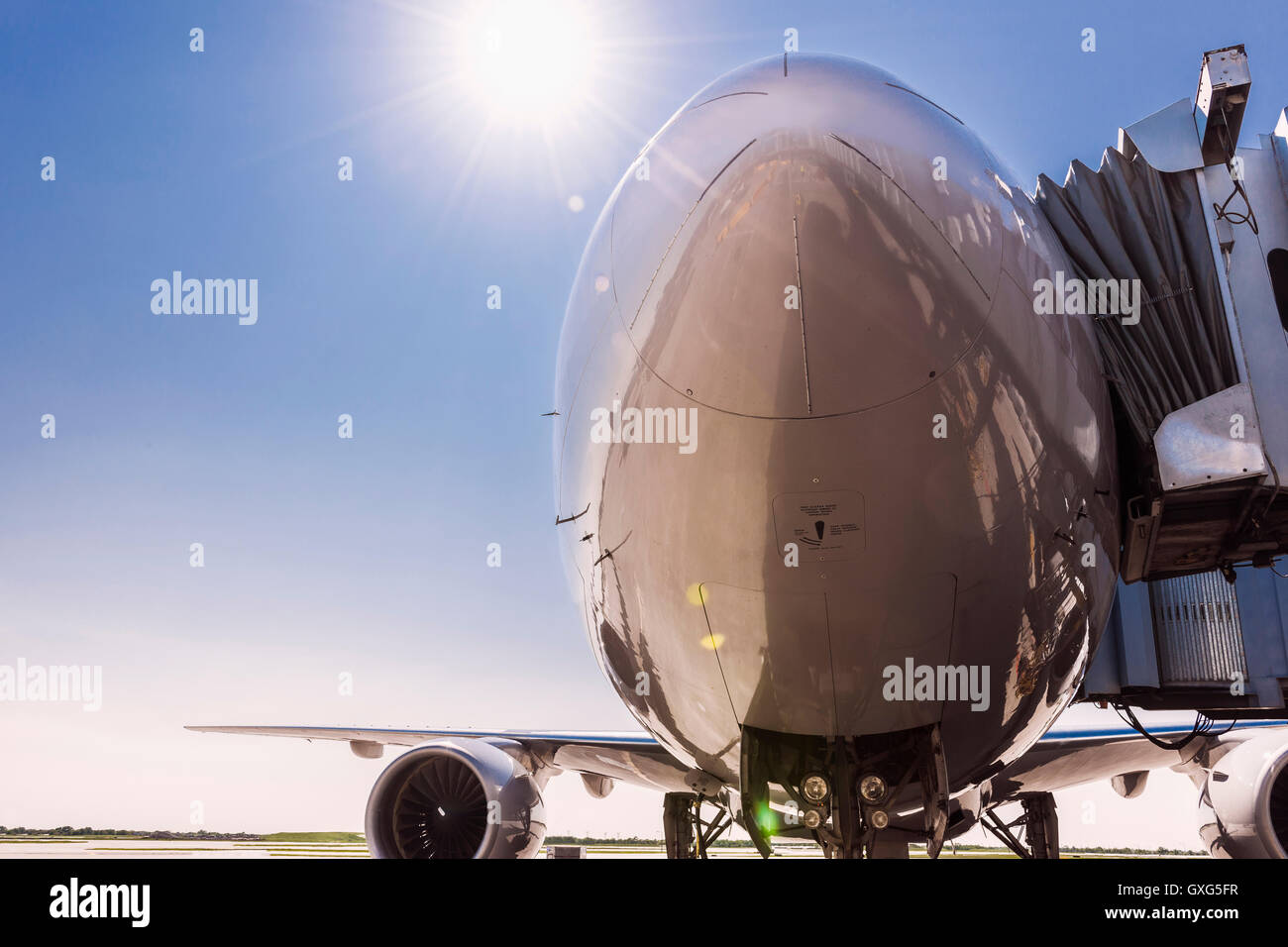 Low angle view of airplane at airport under blue sky Stock Photo - Alamy