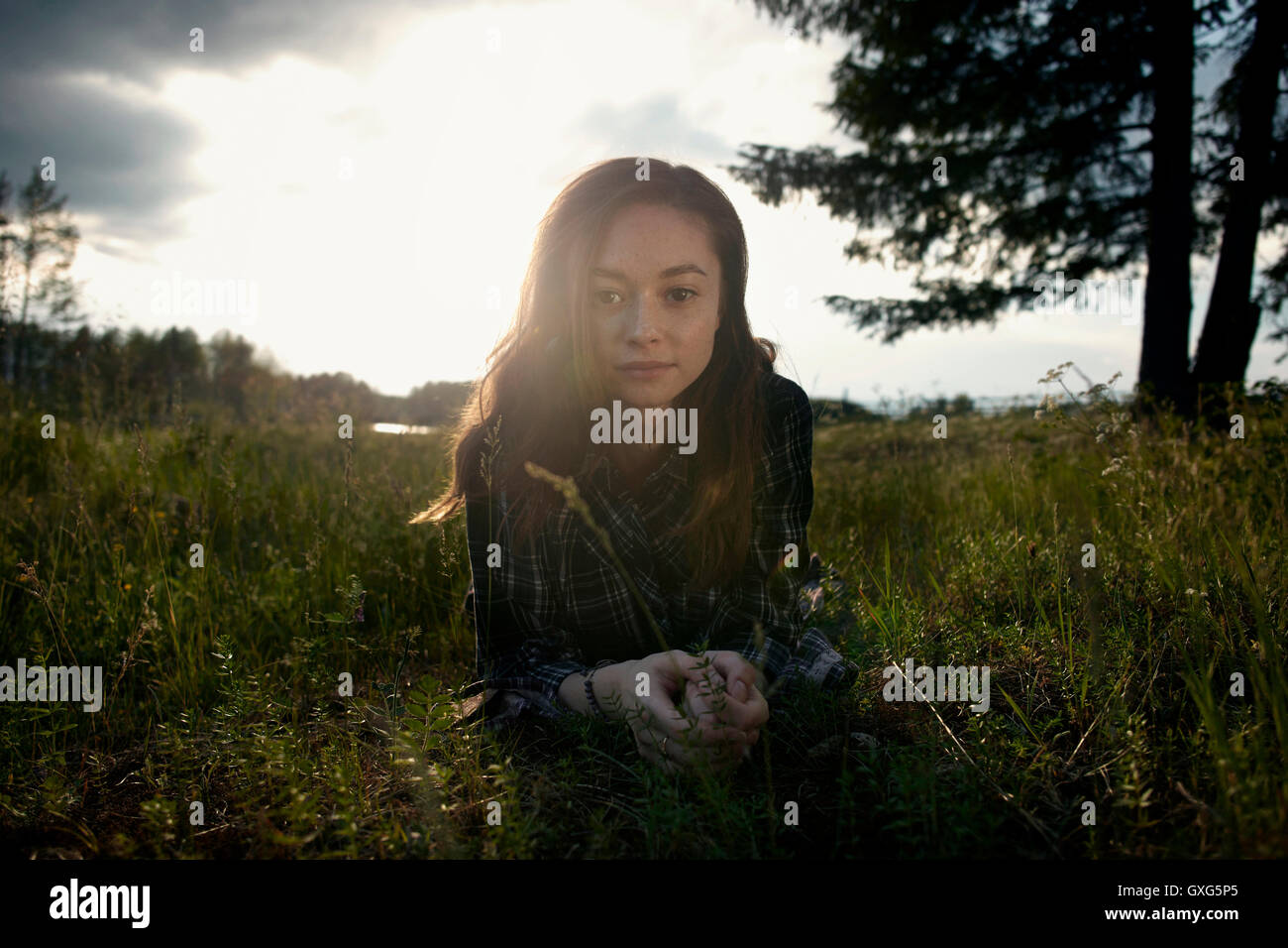 Caucasian girl laying in grass field Stock Photo - Alamy