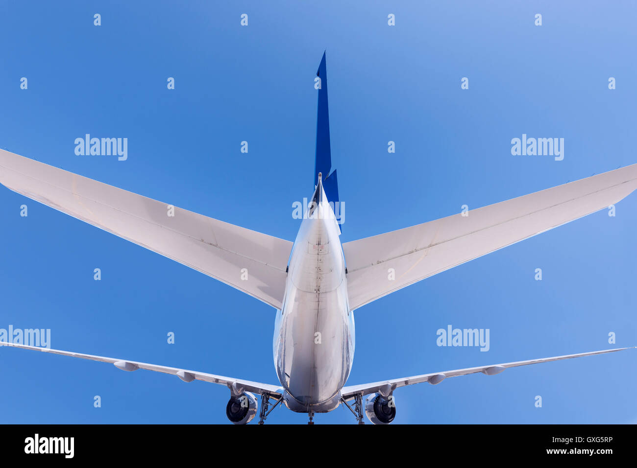 Low angle view of airplane flying in blue sky Stock Photo - Alamy