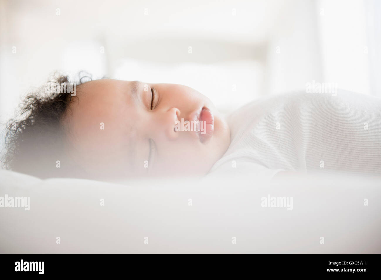 Mixed Race baby boy sleeping on bed Stock Photo - Alamy