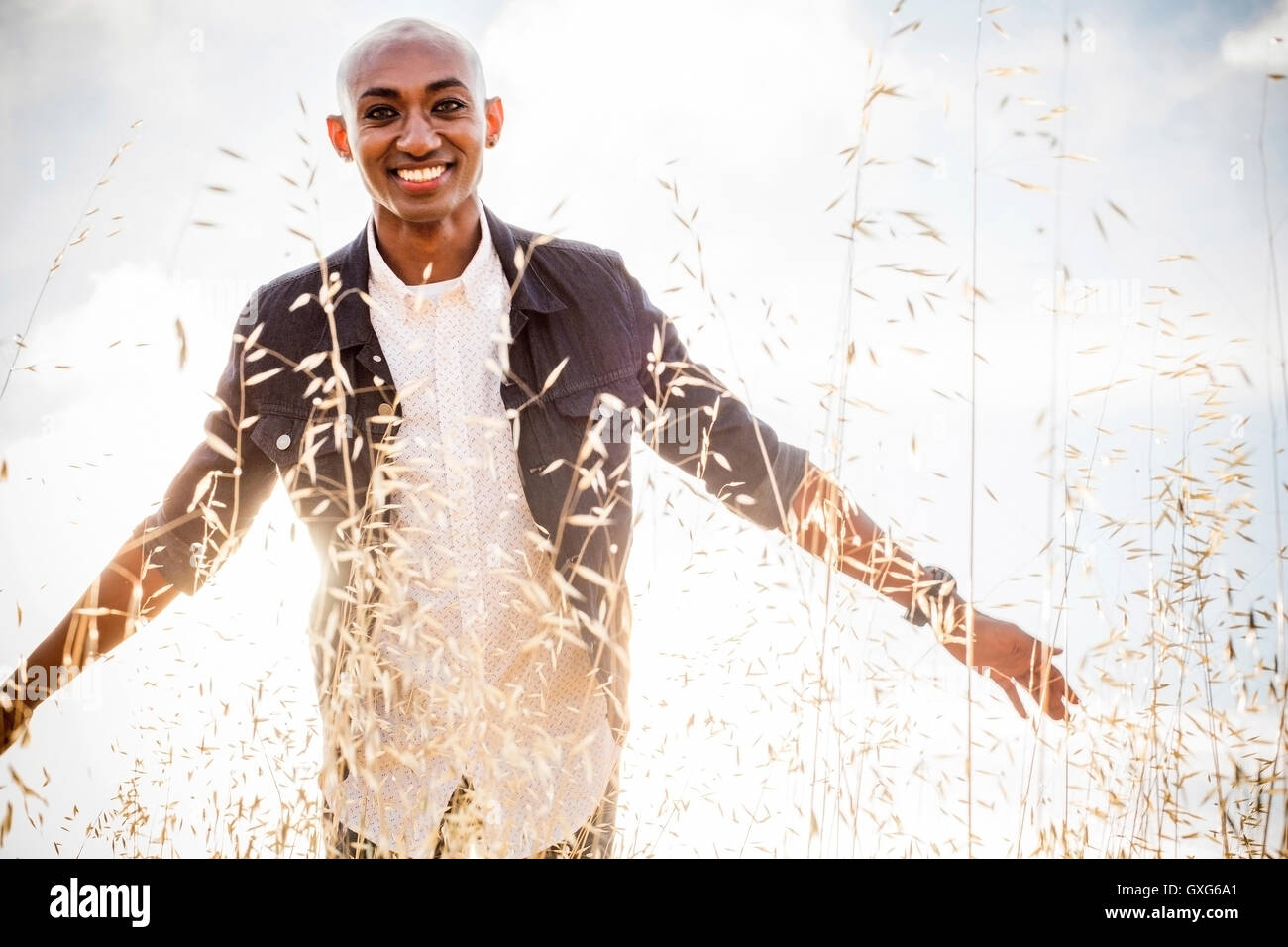 Smiling gay Black man standing in tall grass Stock Photo - Alamy