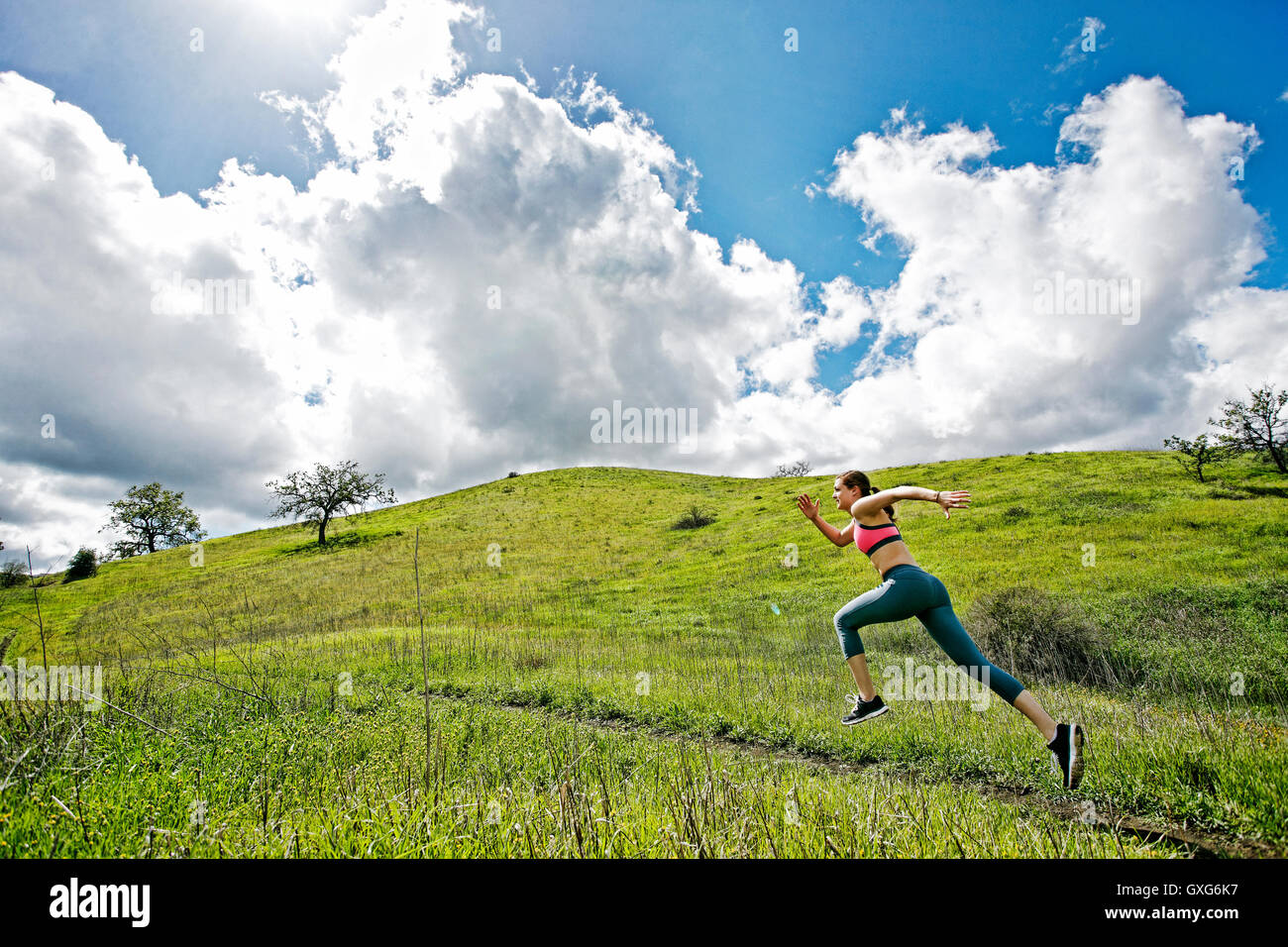 Caucasian woman running on hill Stock Photo - Alamy