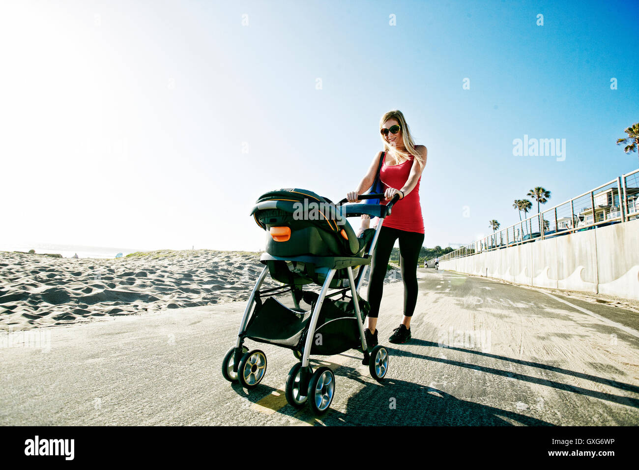 Mother pushing baby son in stroller at beach Stock Photo - Alamy