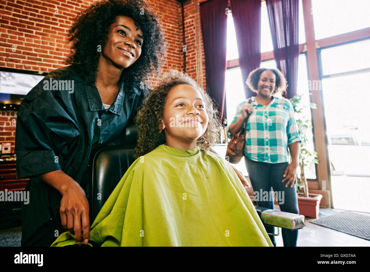 Smiling hairdresser and customers in hair salon Stock Photo - Alamy
