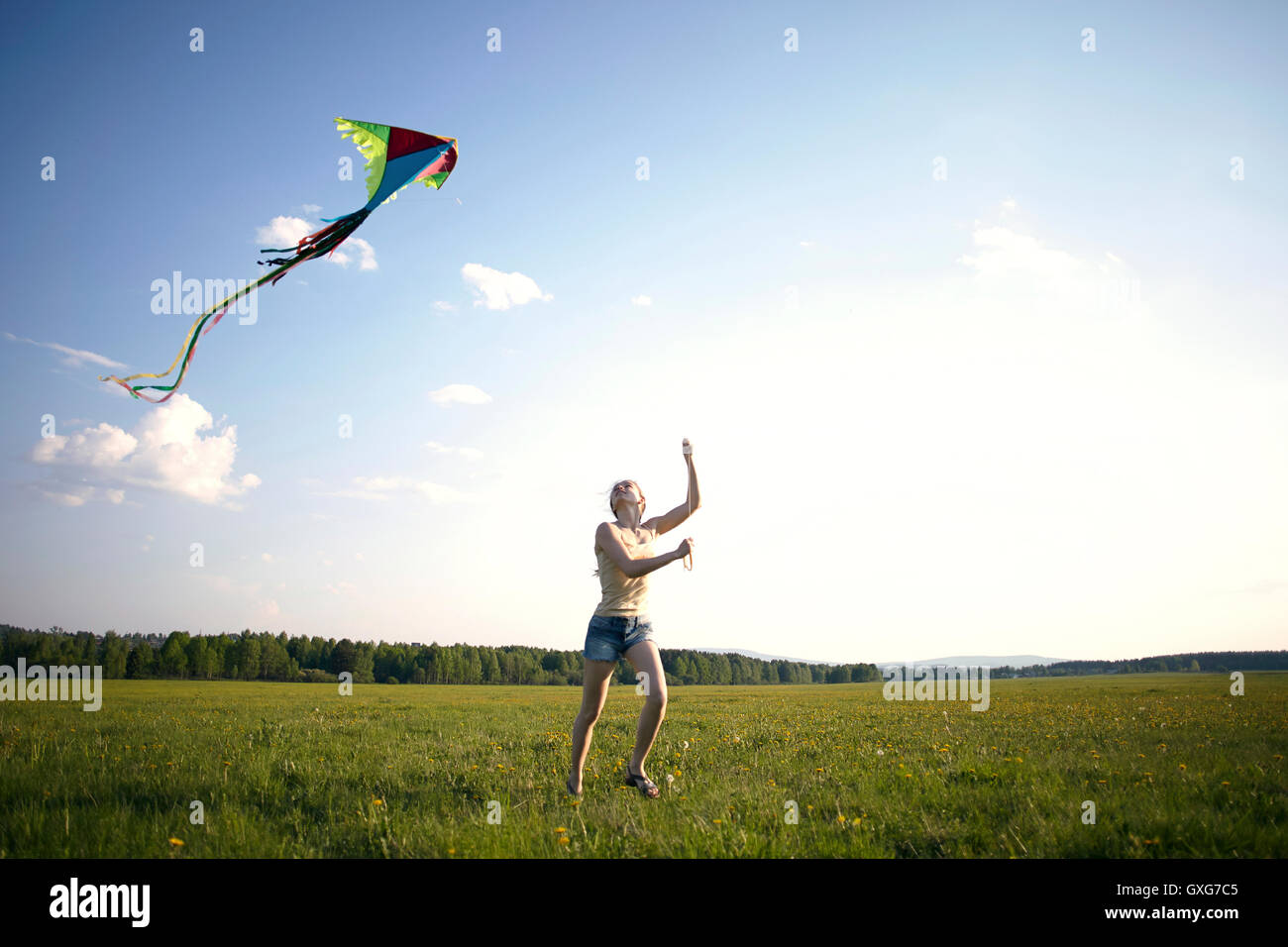 Caucasian girl running in field flying kite Stock Photo - Alamy