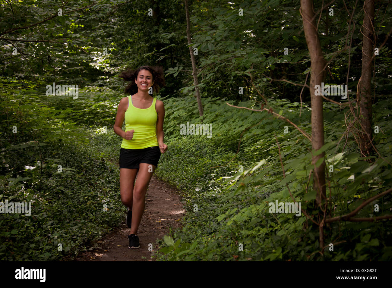 Hispanic woman running on path in forest Stock Photo - Alamy