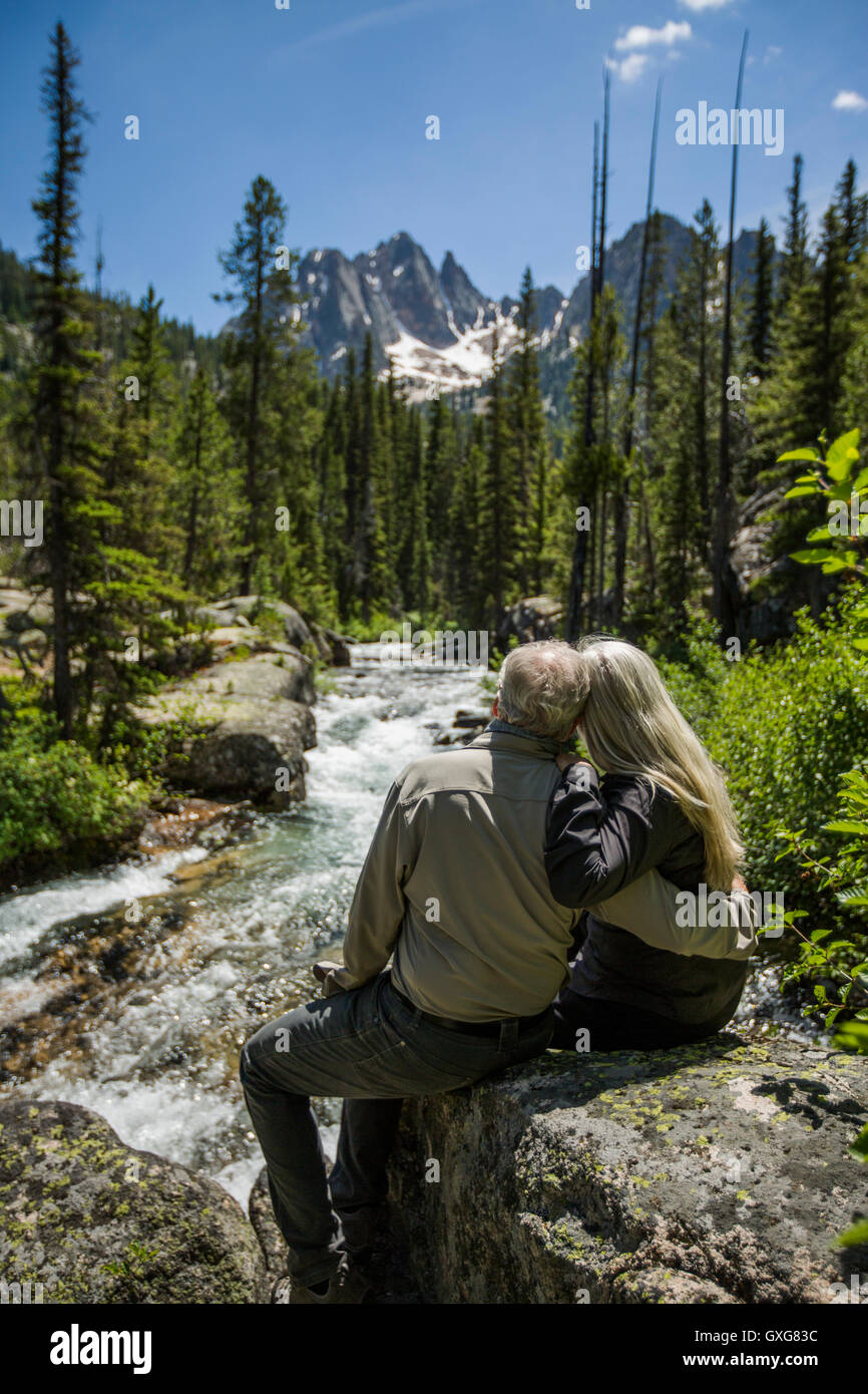 Caucasian couple hugging on rock at mountain river Stock Photo - Alamy