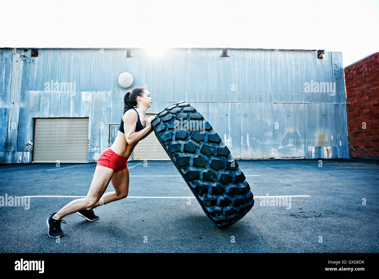 Caucasian woman working out with heavy tire outdoors Stock Photo - Alamy