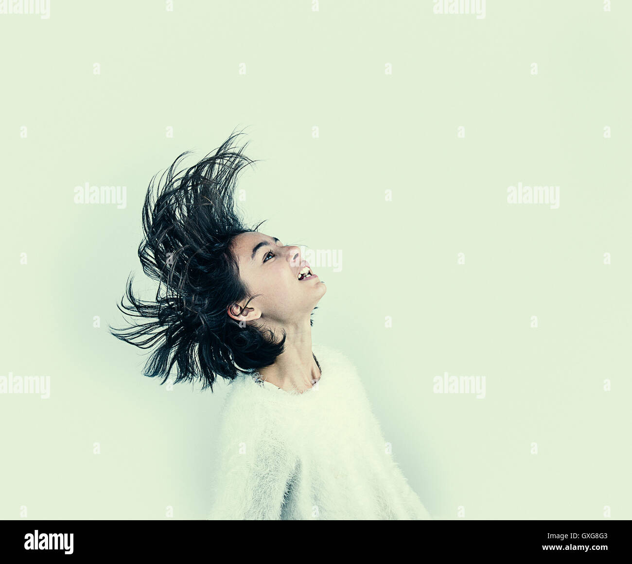 Mixed Race girl tossing hair Stock Photo - Alamy