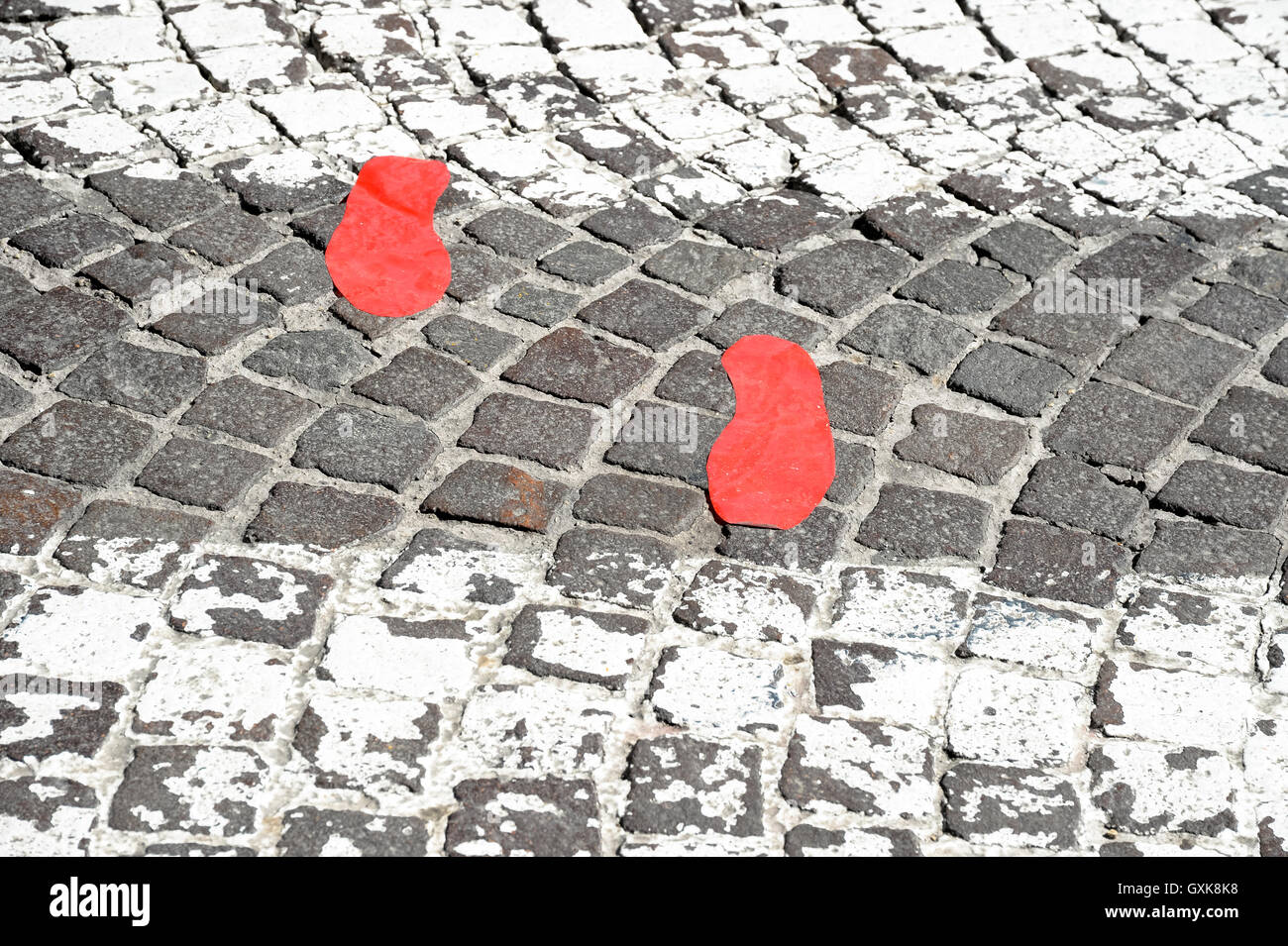 Crosswalk with red footsteps in the pavement Stock Photo - Alamy