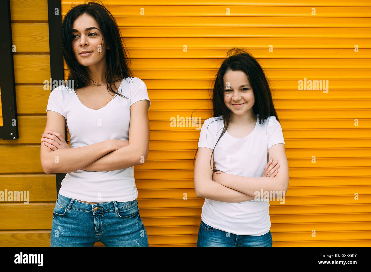 mother and her cute daughter, against wall Stock Photo - Alamy