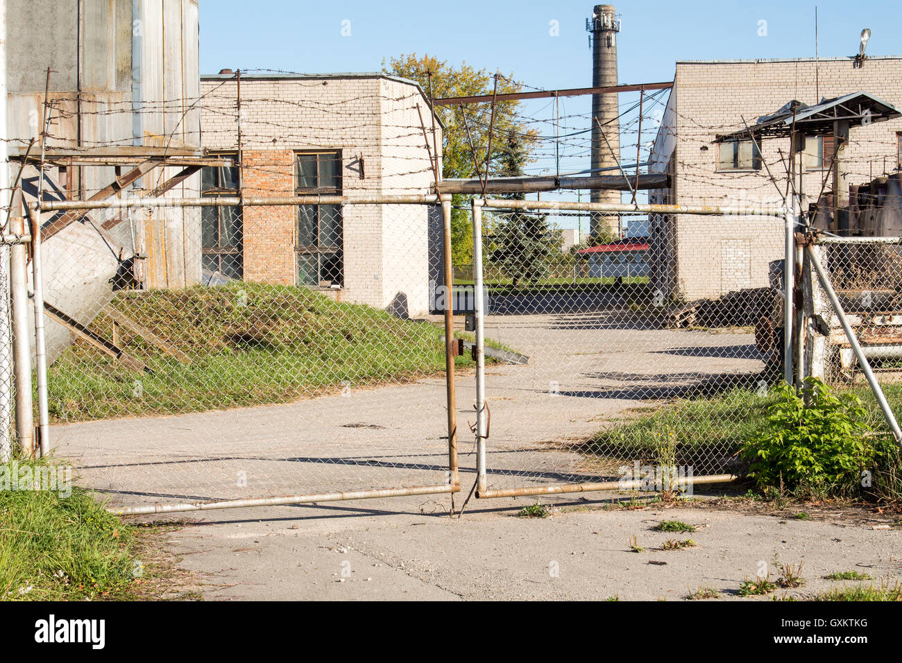 Industrial metal gate with abandoned building in background Stock Photo ...